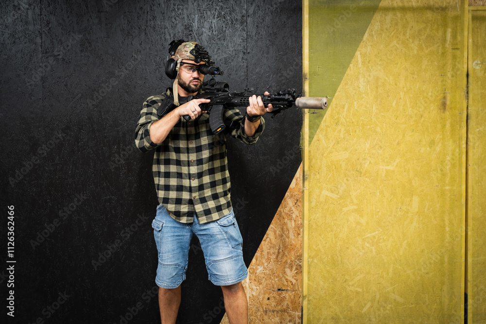Plakát A man in civilian clothes practices tactical shooting with night ...