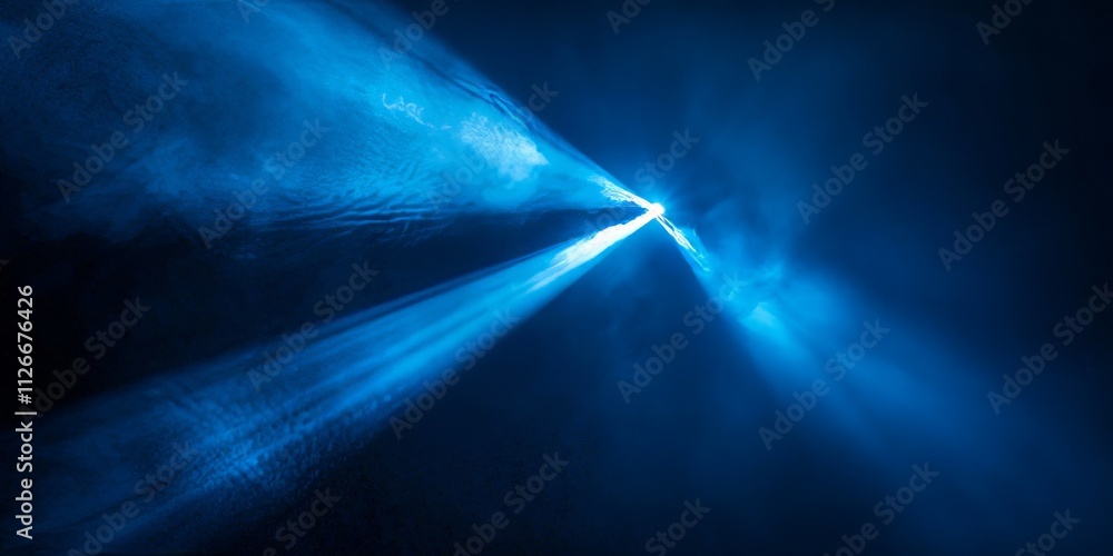 Blue light beam effect created by a spotlight or projector offers a ...