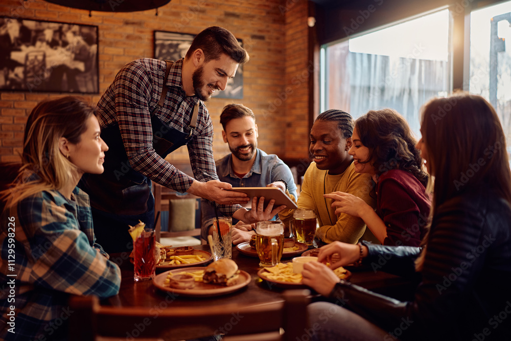 Poster Happy waiter using touchpad while showing menu to group of ...