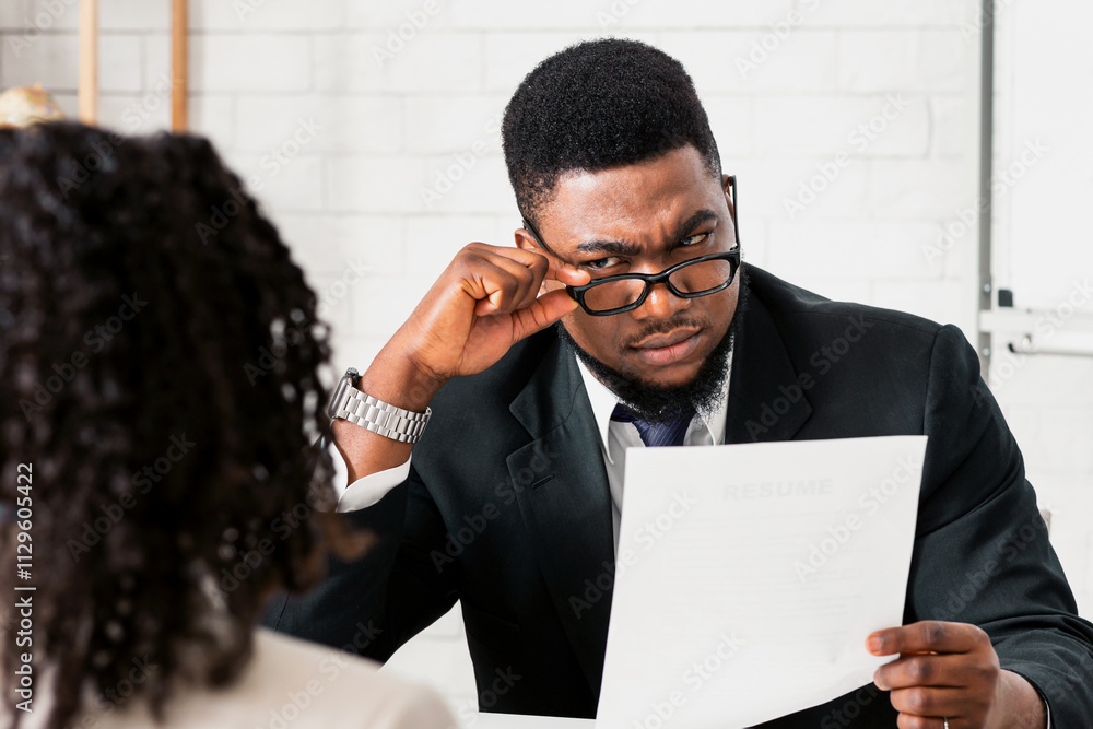 Strict male HR manager reading CV, looking at job applicant with ...