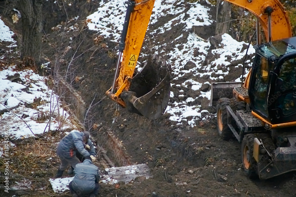 A backhoe loader lays construction slabs, a crew of workers repairs a ...