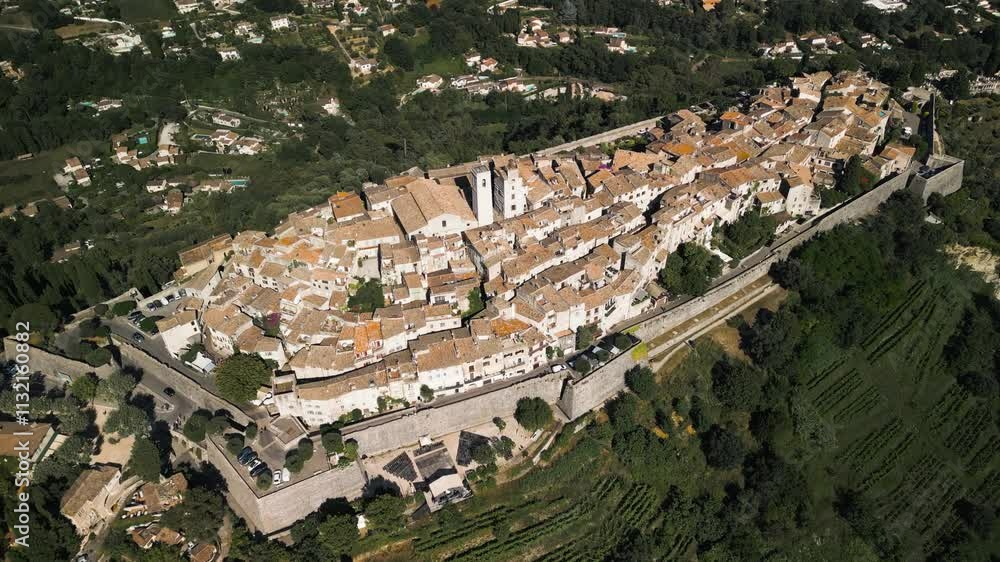 Medieval hilltop village with stone walls and tiled roofs in lush ...