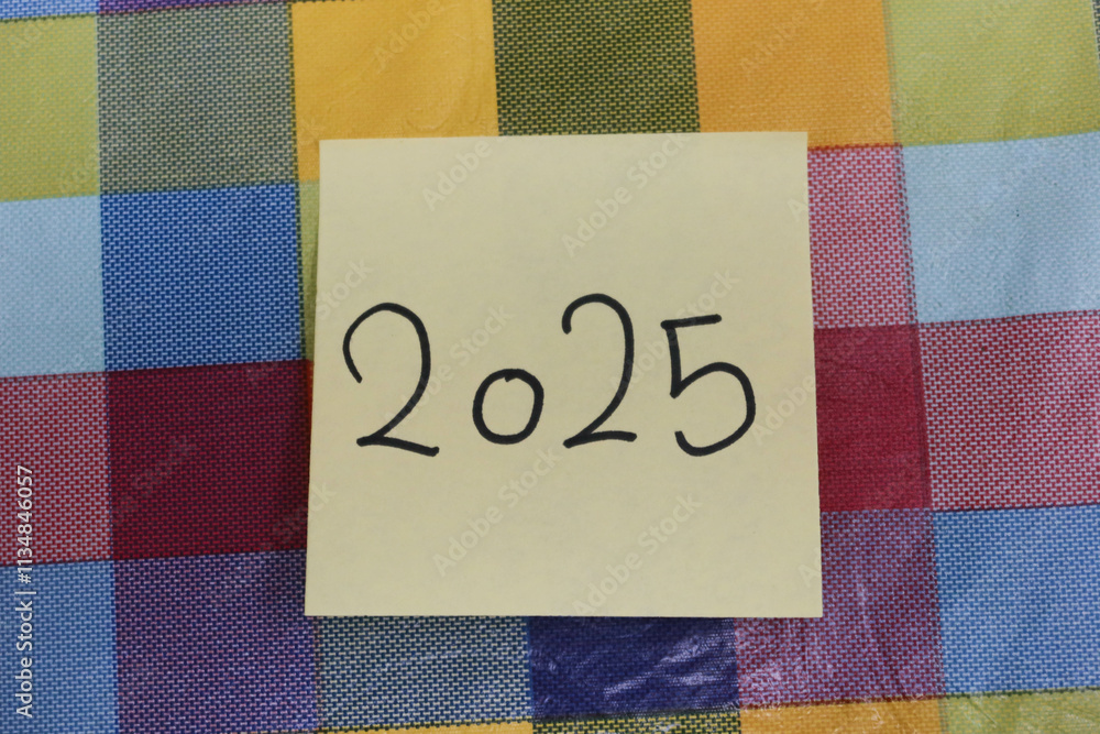 close up of hand written year "2025" on a yellow memo slip on a ...