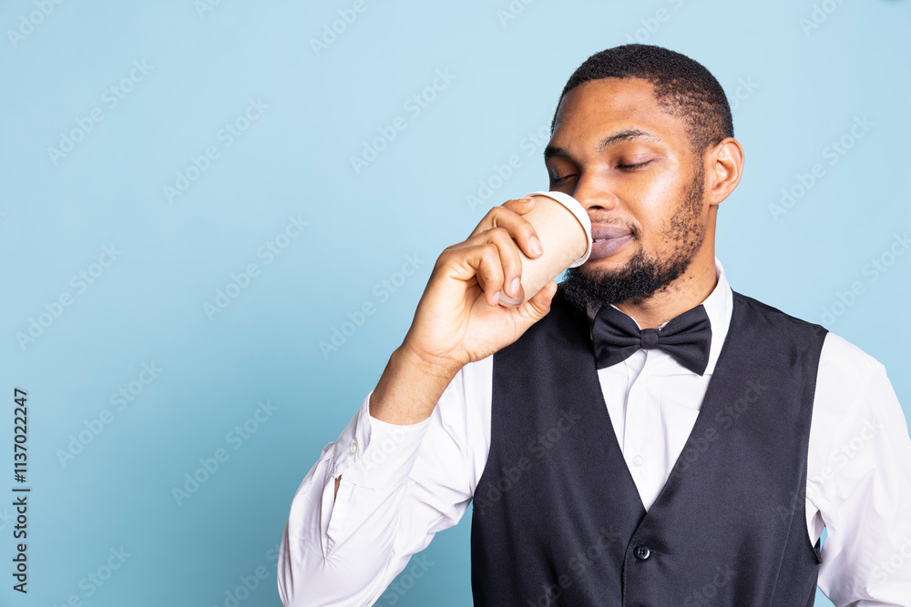 Hotel porter staff drinking a cup of coffee on his work break, working ...