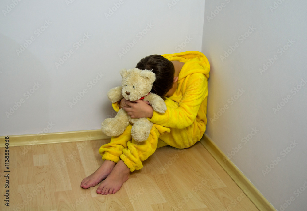Little boy crying with her head down.The child is sitting sad scared on ...