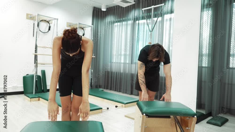 Clients practicing a standing stretch using Wunda Chair equipment ...