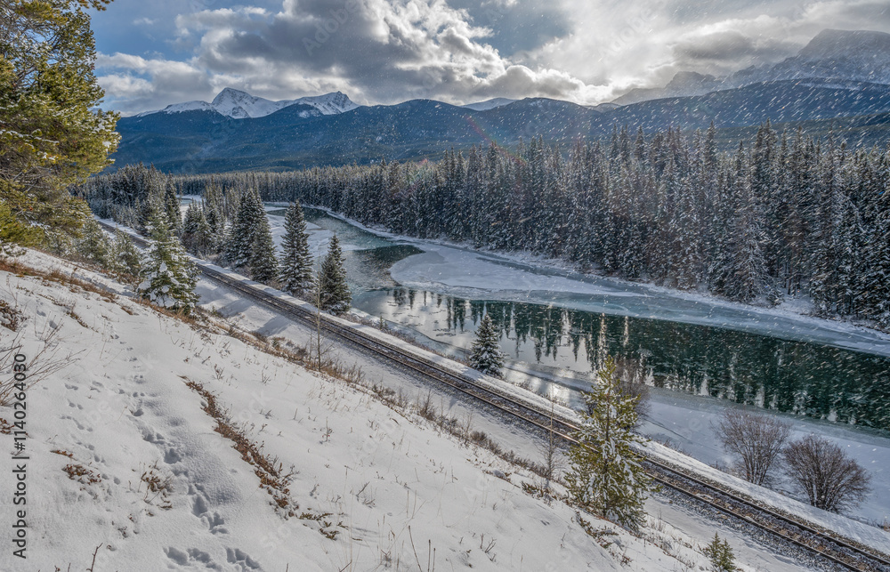 Snow falling over the Bow River and Train Track in Banff National Park ...