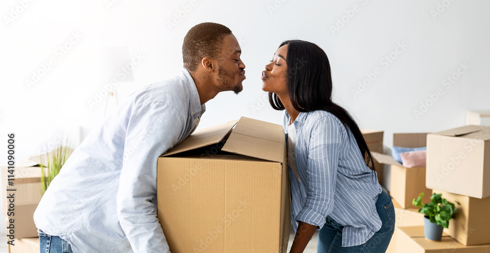 Home relocation concept. Loving african american couple carrying big ...