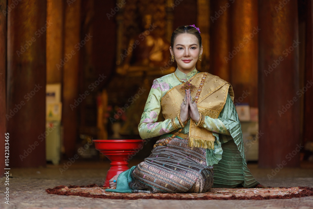 Adorned in a resplendent Thai costume, a lady gracefully sits in a ...