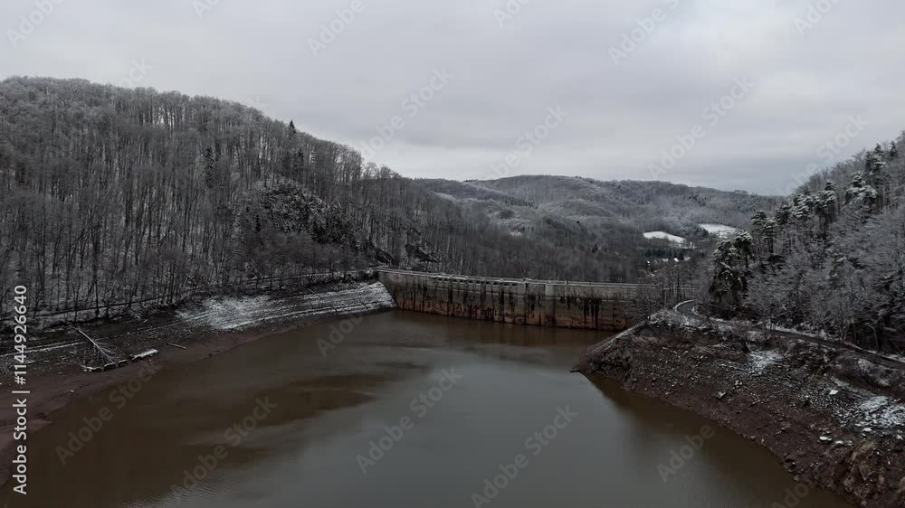 Drone footage shows a dam at the edge of a dried lake, with exposed ...