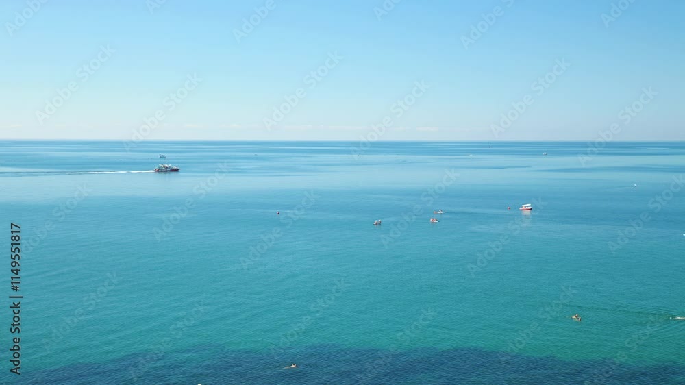 The vast turquoise sea stretches as far as the horizon. In the distance ...