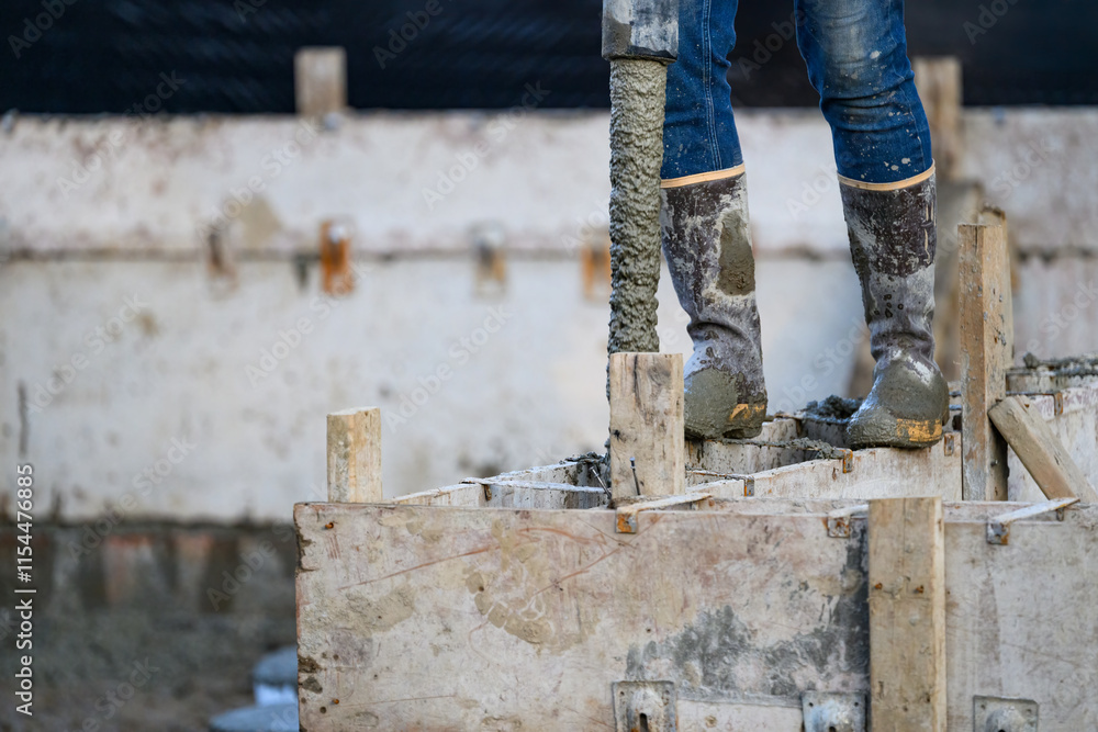 Construction worker walking on wood cement form panels for foundation ...