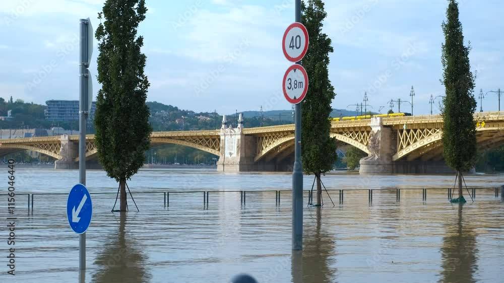 Water level rising on flooded river embankment. River overflowing its ...