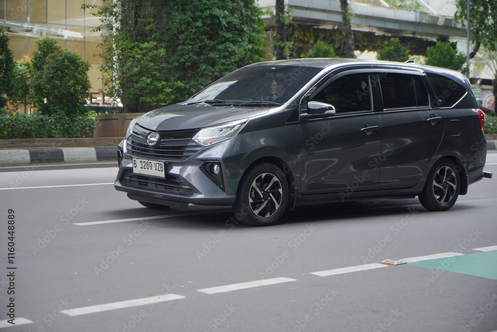 cars on the road ,Multi purpose Vehicle (MPV), dark gray color Daihatsu ...