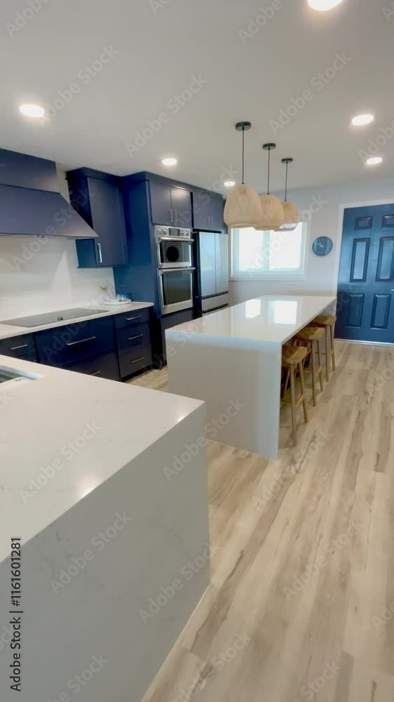 Vertical video of a modern coastal condo kitchen with blue cabinets ...
