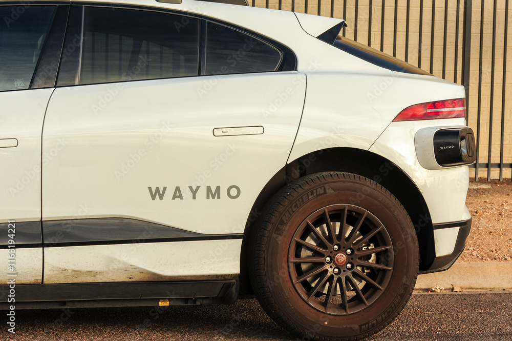 A partial rear-end view of a white Jaguar Waymo self-driving vehicle ...