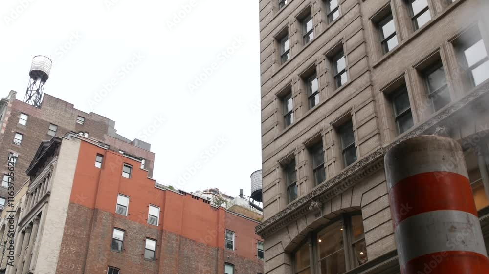 Steam vapor vented on New York City street, orange vapour tube stack ...