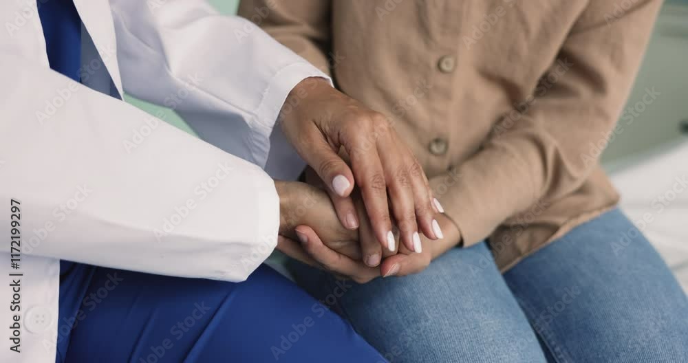Female doctor giving support to patient on consultation, touching and ...