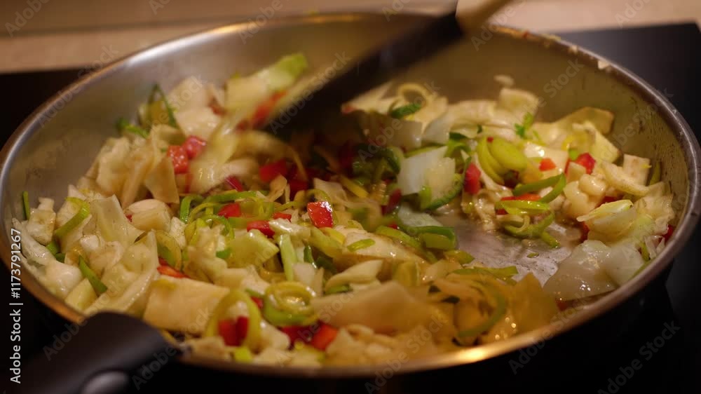 plan fixe vidéo avec remuage de légumes variés, dans une poêle inox, à ...
