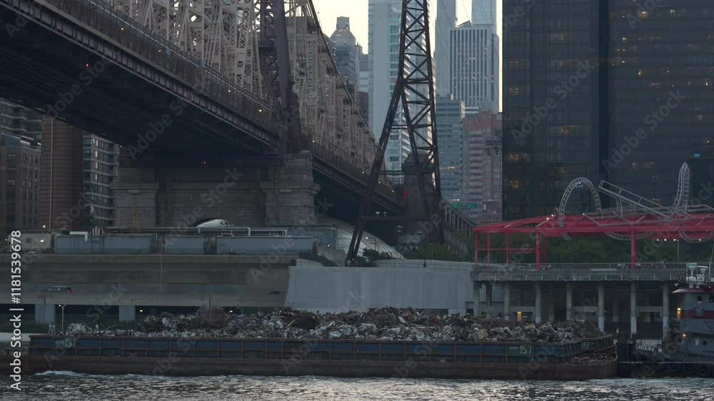 A barge carrying scrap metal floats along the river under the ...