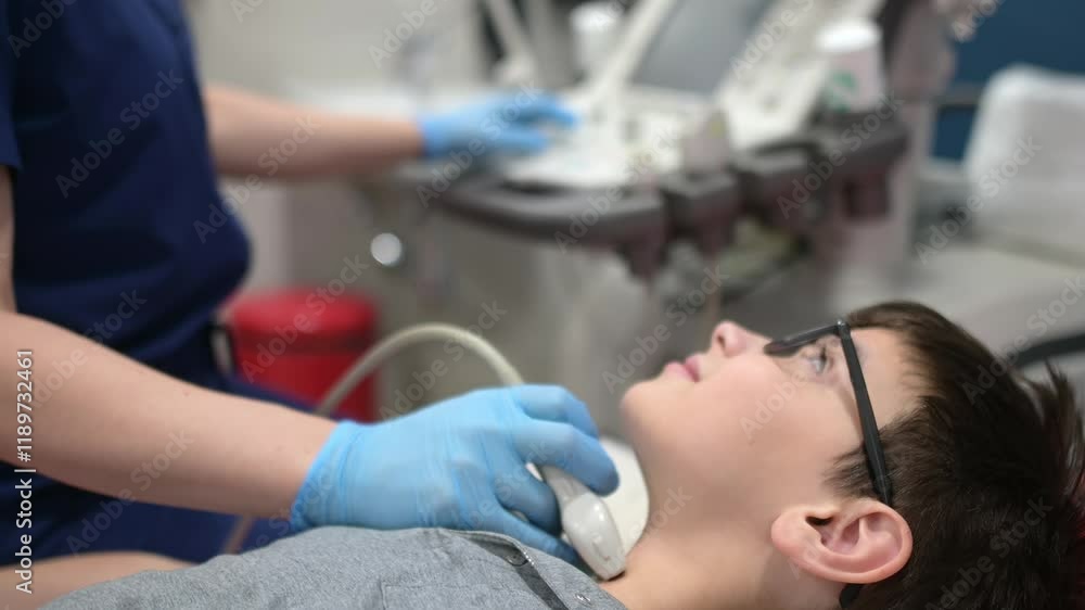 Doctor making sonogram of thyroid gland for boy using scanner machine ...