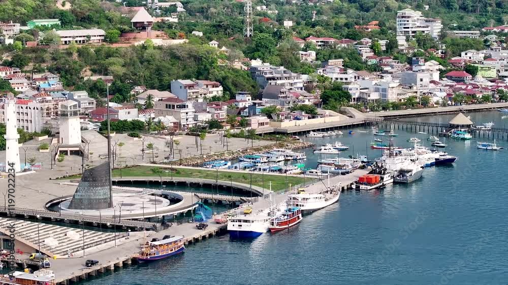 Labuan Bajo Marina, lighthouse and docked boats, waterfront with houses ...