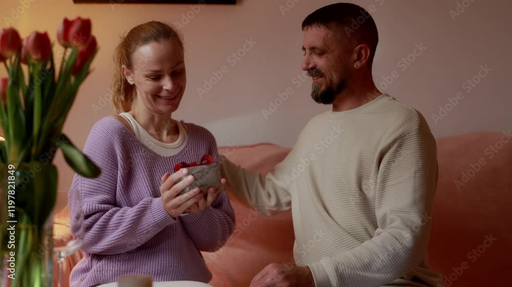 Loving pair trading meaningful presents, embracing warmly while sharing ...