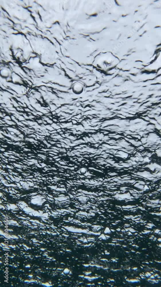 Underwater view of raindrops falling on the water surface of the ocean ...