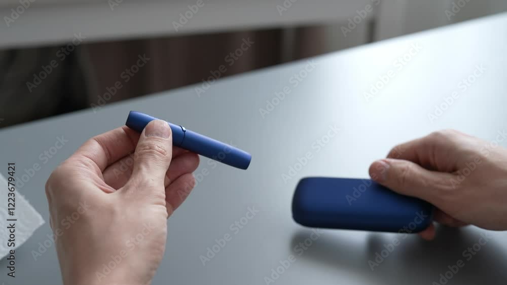 Close-up revealing heated tobacco stick insertion into sleek iqos ...