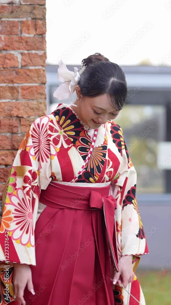 A young woman in her 20s takes a video blog at a traditional graduation ...