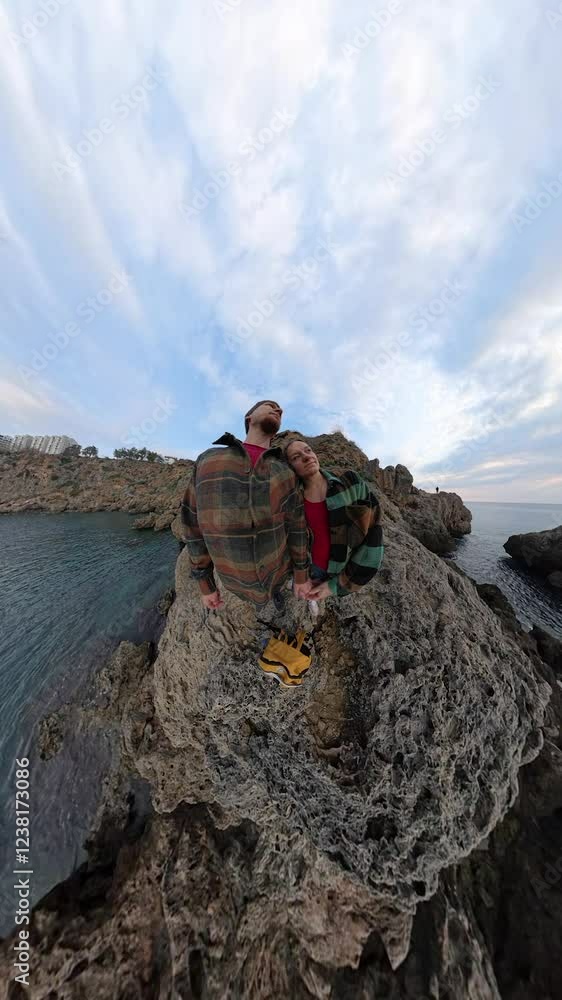 Vertical video. A Couple Sharing a Kiss on Jagged Rocks by the Ocean ...