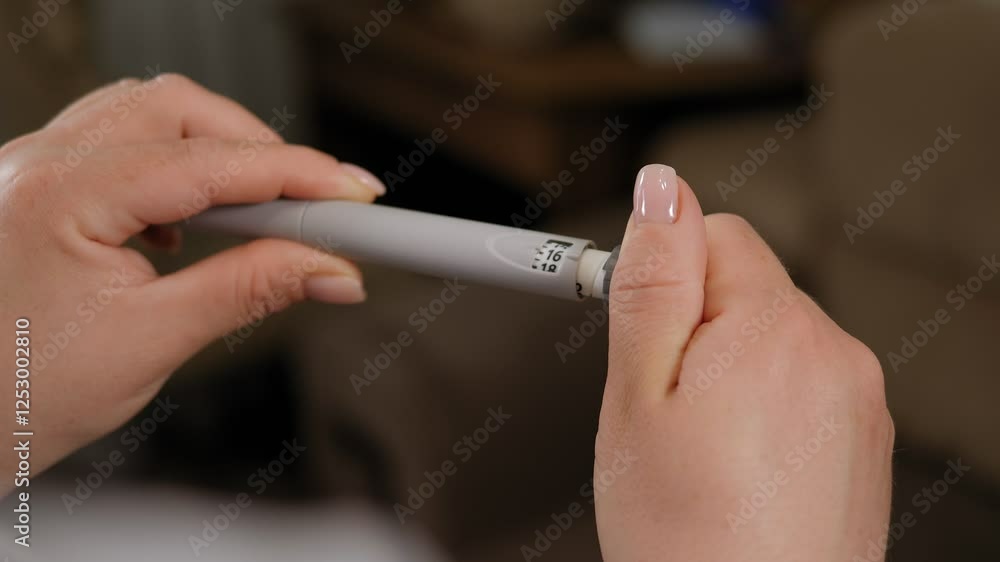 Close-up of an unrecognizable diabetic woman dialing the correct dose ...
