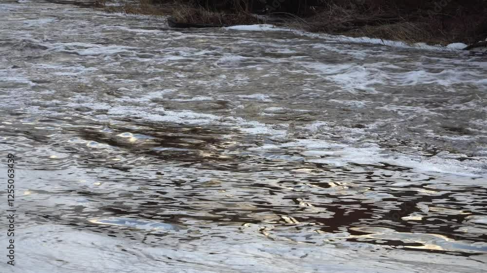 A vigorous water current in a river overflowing and flooding the ...