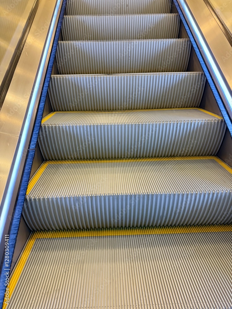 Poster Close-up view of an escalator with metallic grooved steps and ...