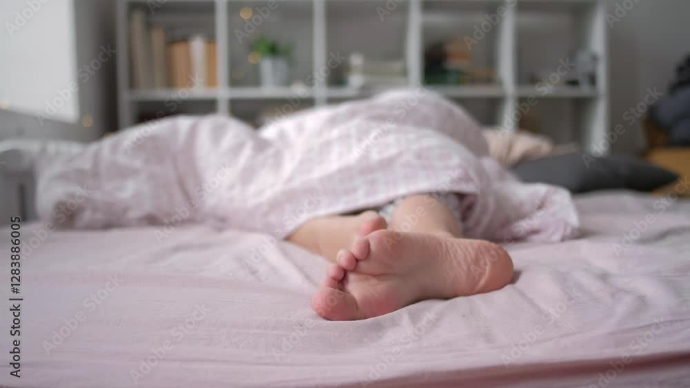 Female feet under blanket flat lay. Female beautiful feet with red ...