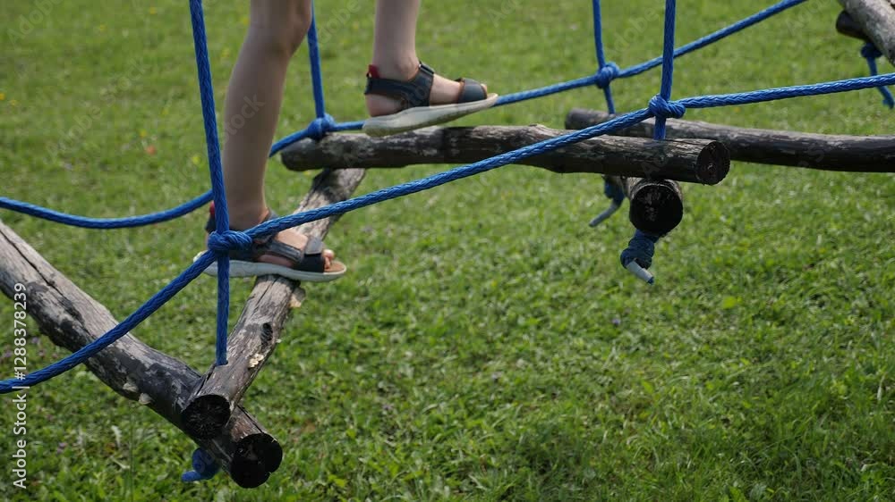 Close-up of a little boy's feet on an obstacle course in a rope park in ...