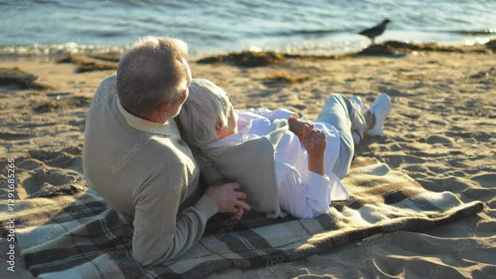Senior mature couple sitting on beach hugging enjoying outdoor ...