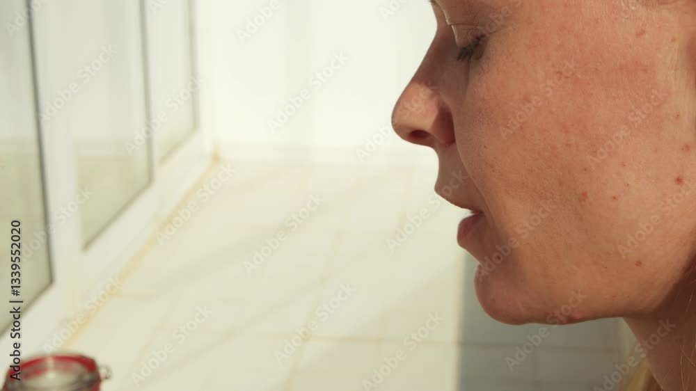 Middle-aged woman carefully consuming food using fork, demonstrating ...
