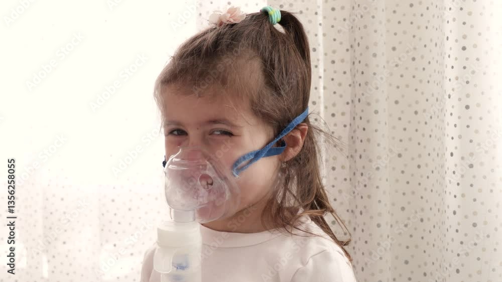 Cute little girl in the mask of an inhaler. Procedure of inhalation at ...