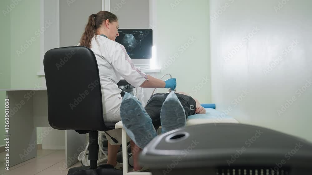 Professional clinical scientist seated in scan room examining patient ...