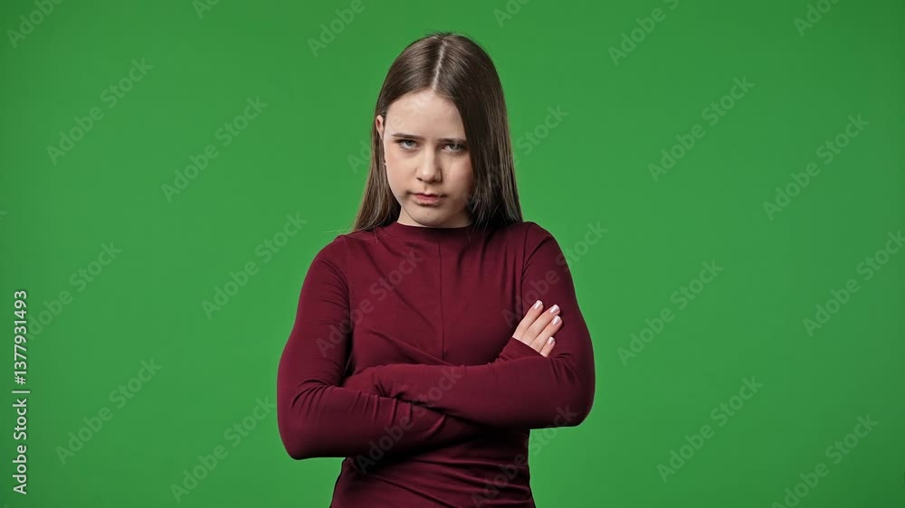 Teenage girl posing at camera with crossed arms sighing with frustrated ...