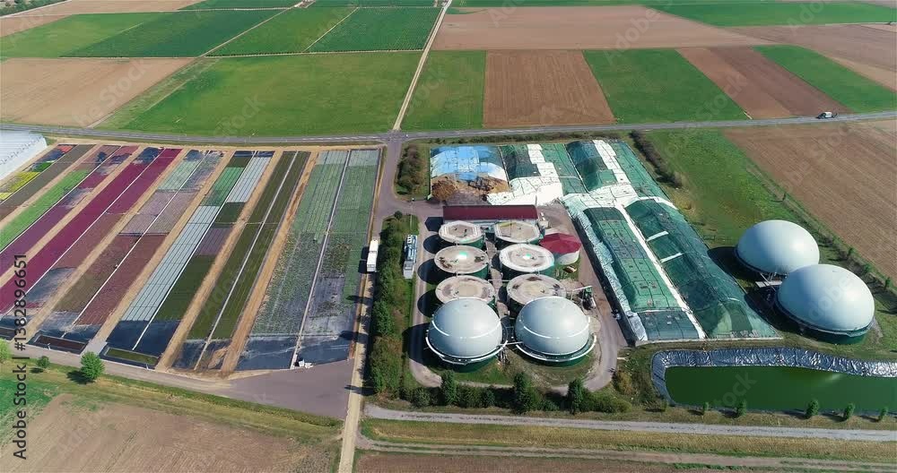 The concept of renewable energy from biomass. An aerial view of a biogas plant and smart ...