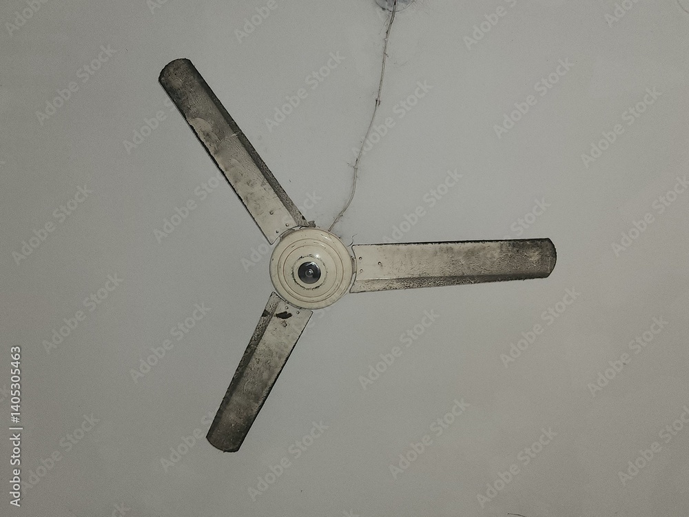 Blade of ceiling fan full of dust. Cream colored ceiling fan on a white ...