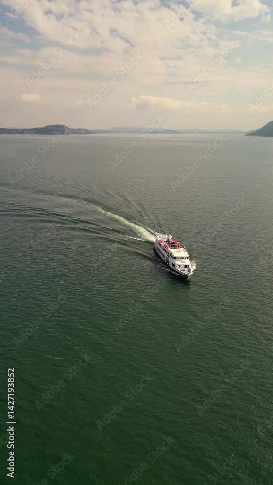 Drone view of a tourist ferry cruising on Lake Como, Italy. Public boat ...