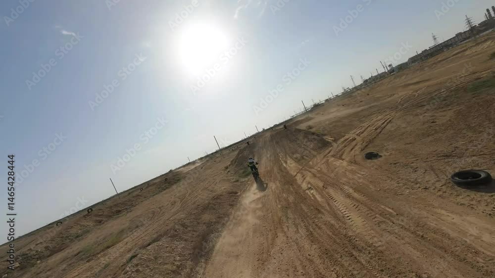 motocross rider goes up a ramp and makes a jump lifting one leg up from ...
