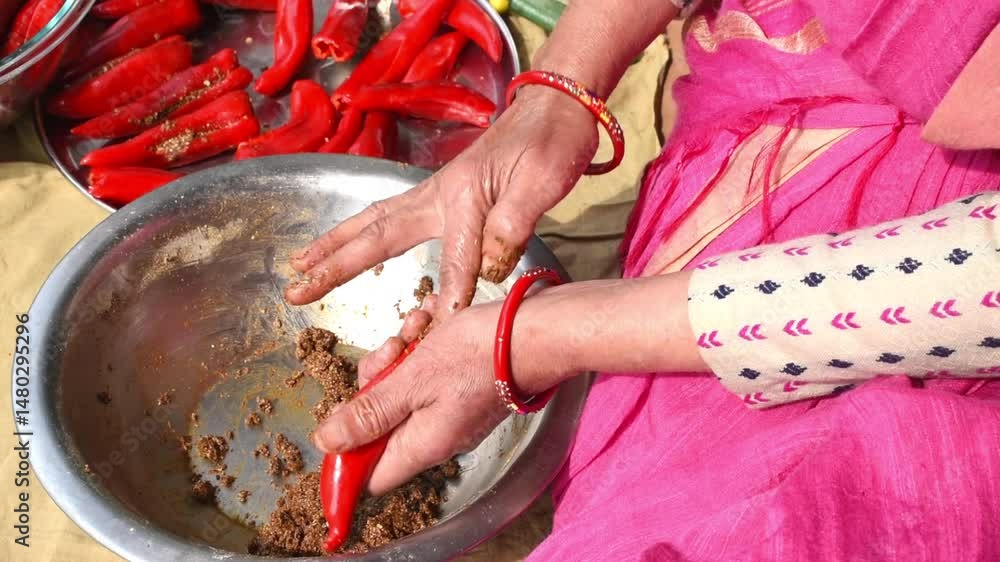 Red chilli pickle recipe made by an Indian old lady . old lady having ...