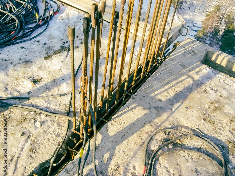Poster A high-angle shot depicts construction rebar and cables on a ...