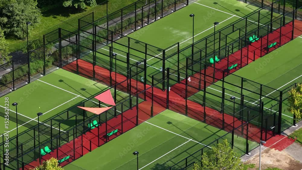 Overhead view of vibrant green and red outdoor padel and tennis courts ...