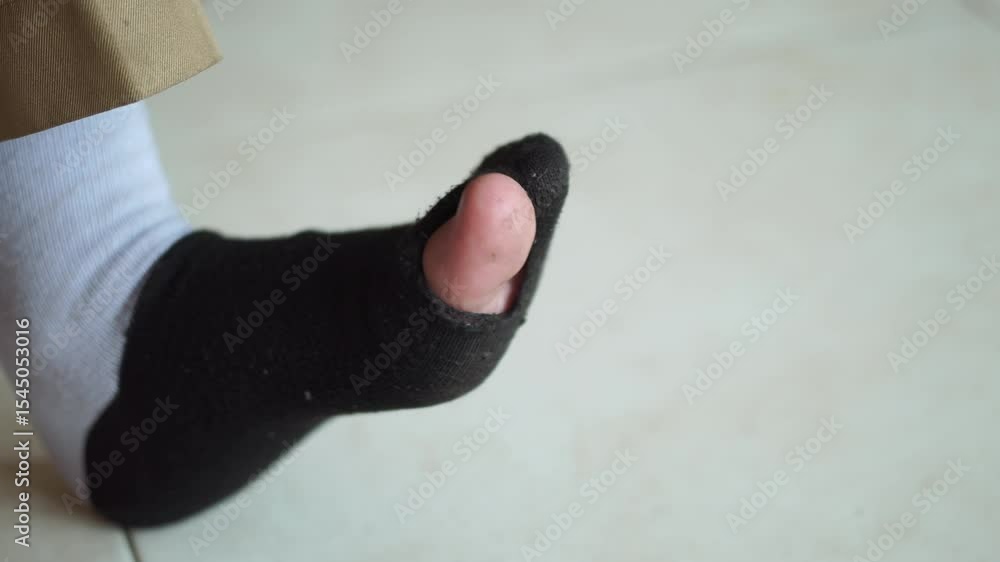 The boy was wearing worn-out school socks with a hole in the big toe ...