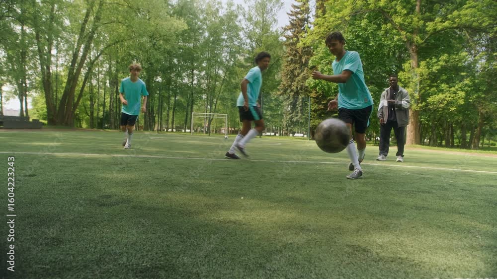 Three young diverse soccer players actively competing on grassy field ...